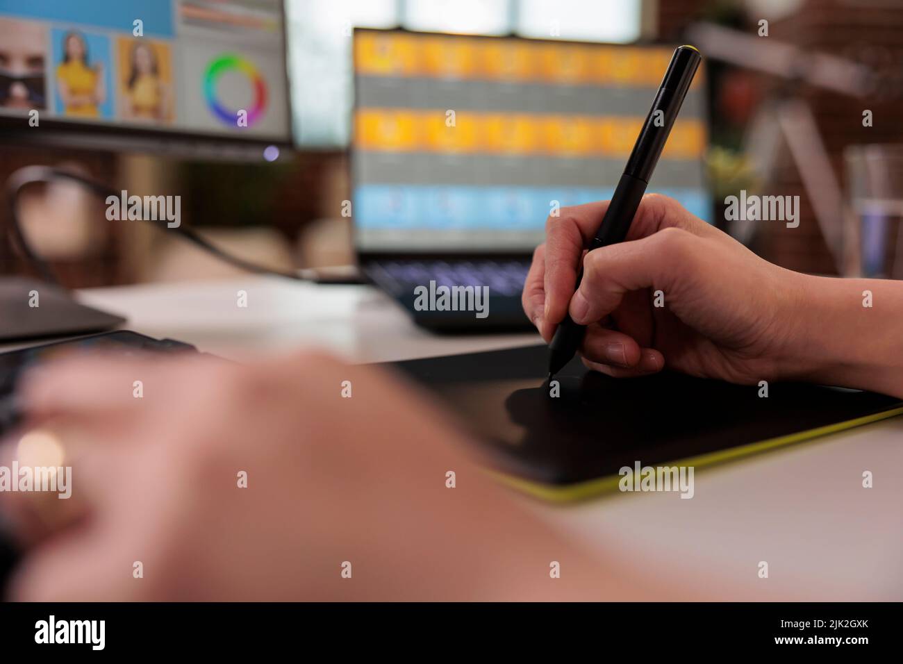 Retouching artist using stylus on graphic tablet to edit photo ...