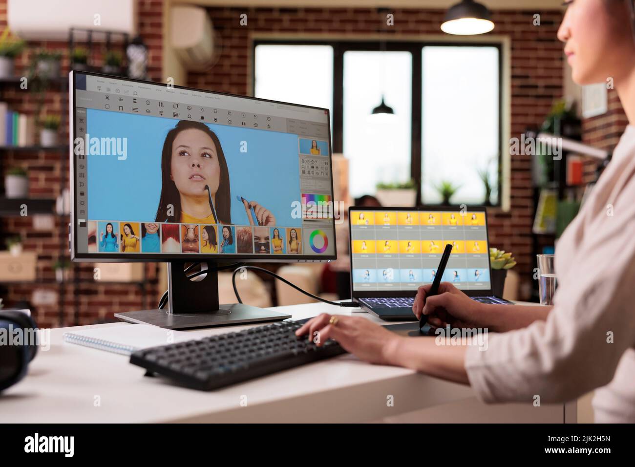 Asian photographer editing picture with retouching software on computer ...