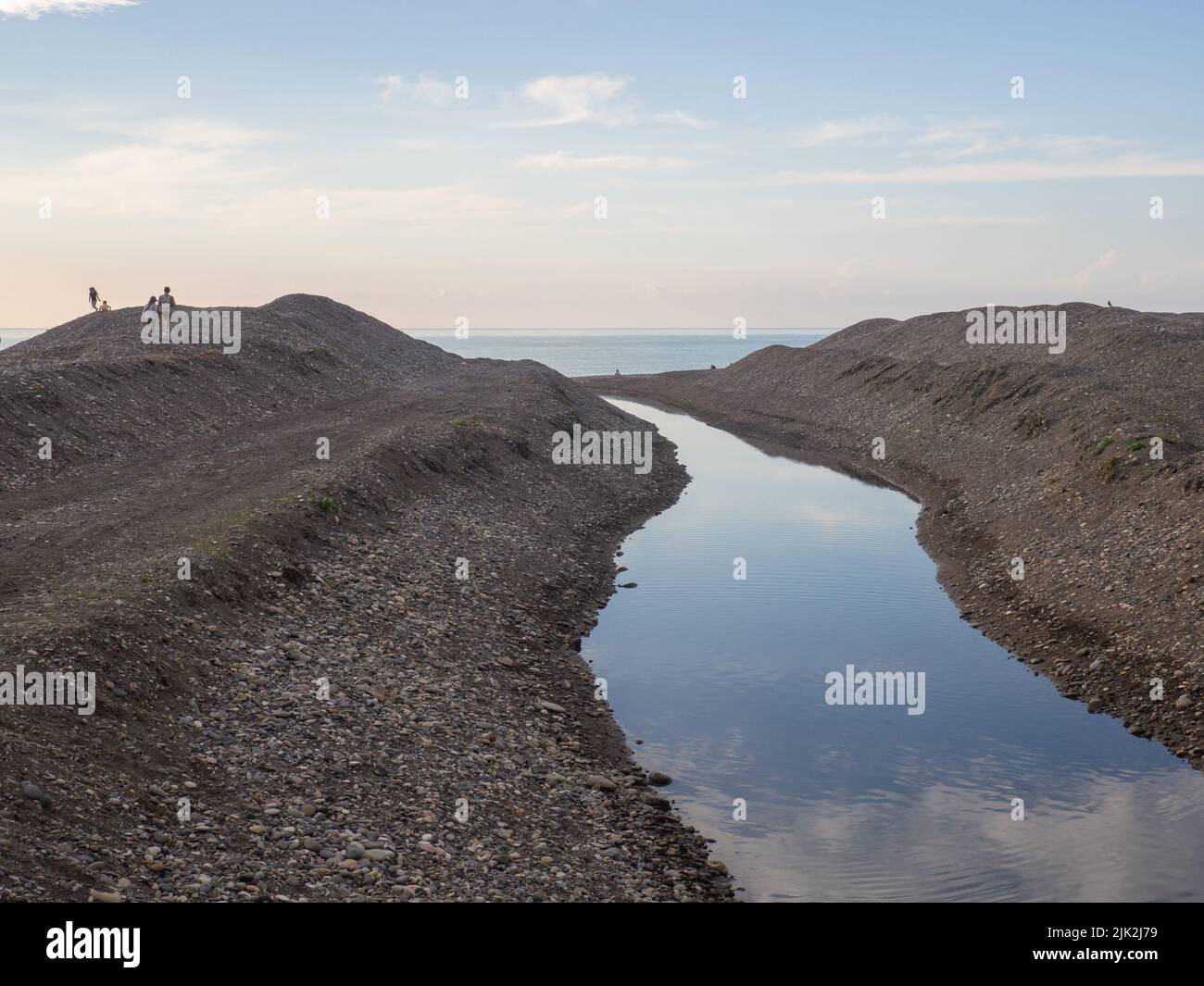 Mouth of a river flowing into the sea. Quiet backwater. Heaps of rubble ...