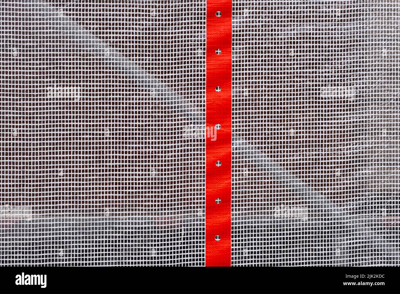 a white barrier net in front of scaffolding with a red stripe Stock ...