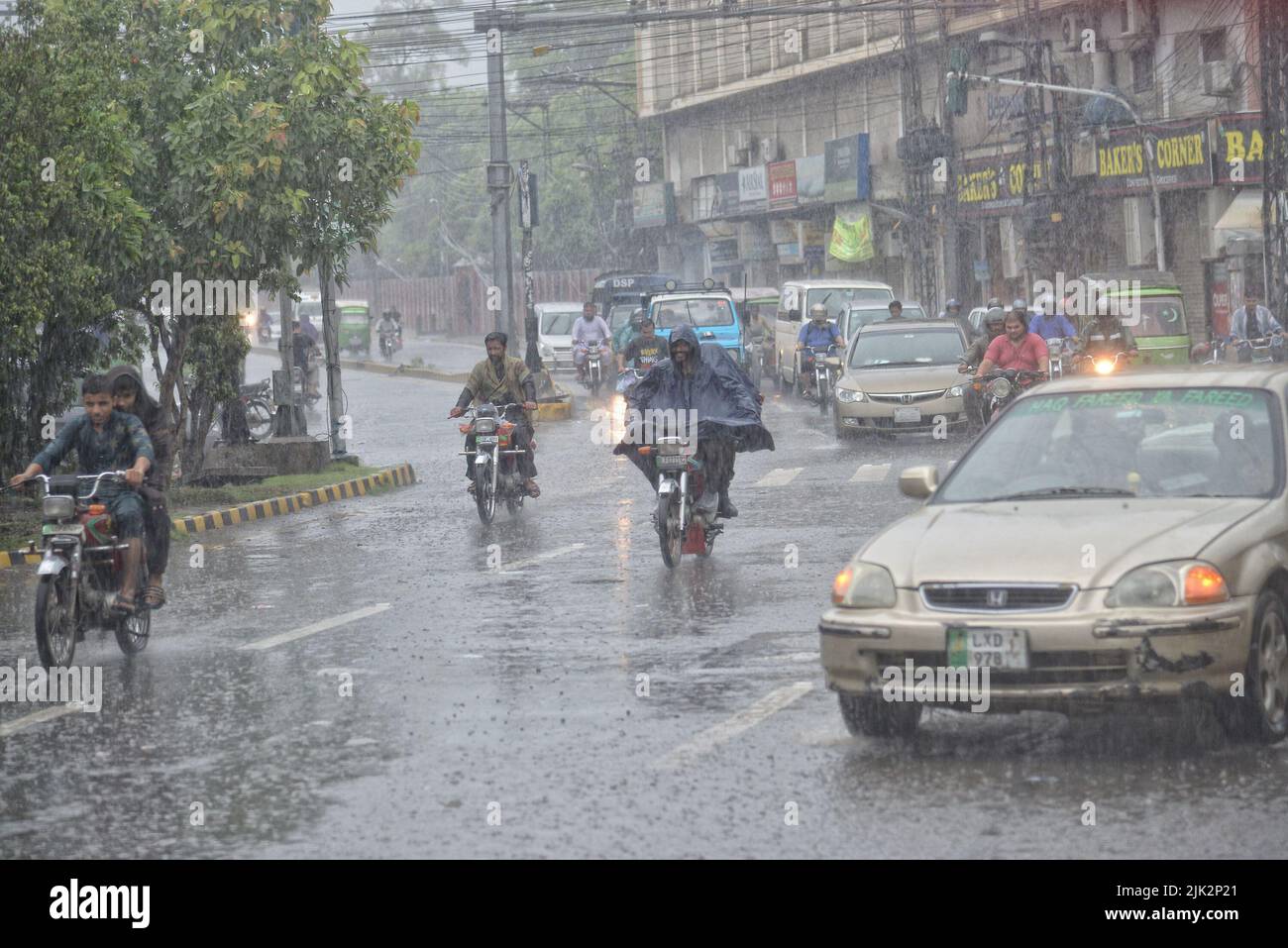 Lahore, Punjab, Pakistan. 21st July, 2022. Pakistani people wade through a flooded road after ...