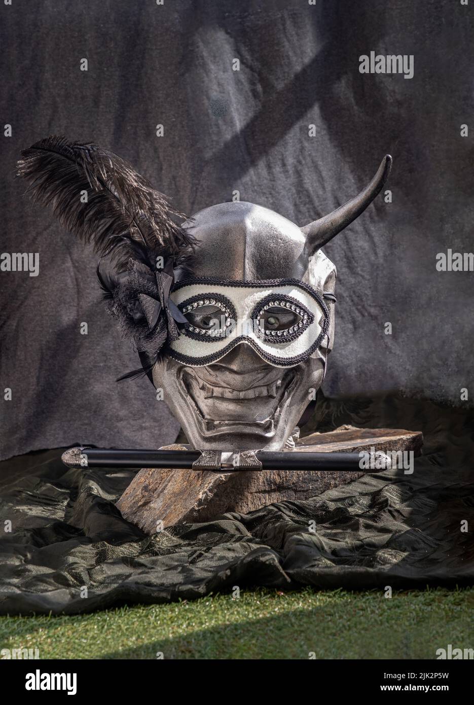 Traditional japanese mask of a demon wearing in black and white mysterious venetian mask with ...