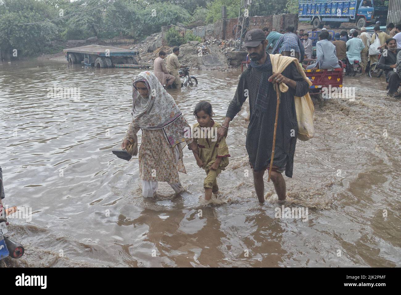 Lahore, Punjab, Pakistan. 21st July, 2022. Pakistani people wade through a flooded road after ...