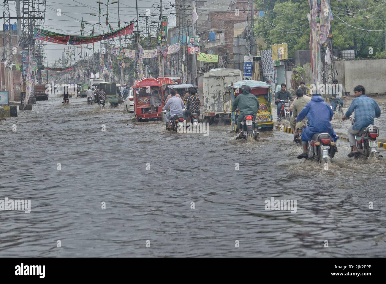 Lahore, Punjab, Pakistan. 21st July, 2022. Pakistani people wade through a flooded road after ...
