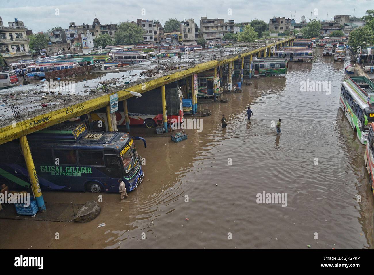 Lahore, Punjab, Pakistan. 21st July, 2022. Pakistani people wade through a flooded road after ...