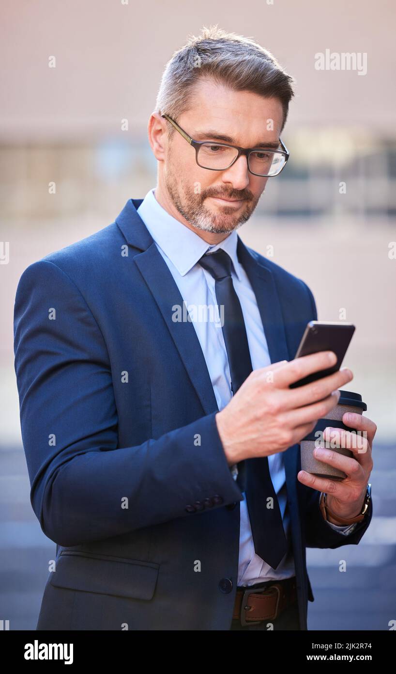Checking his messages. a handsome mature businessman texting while ...