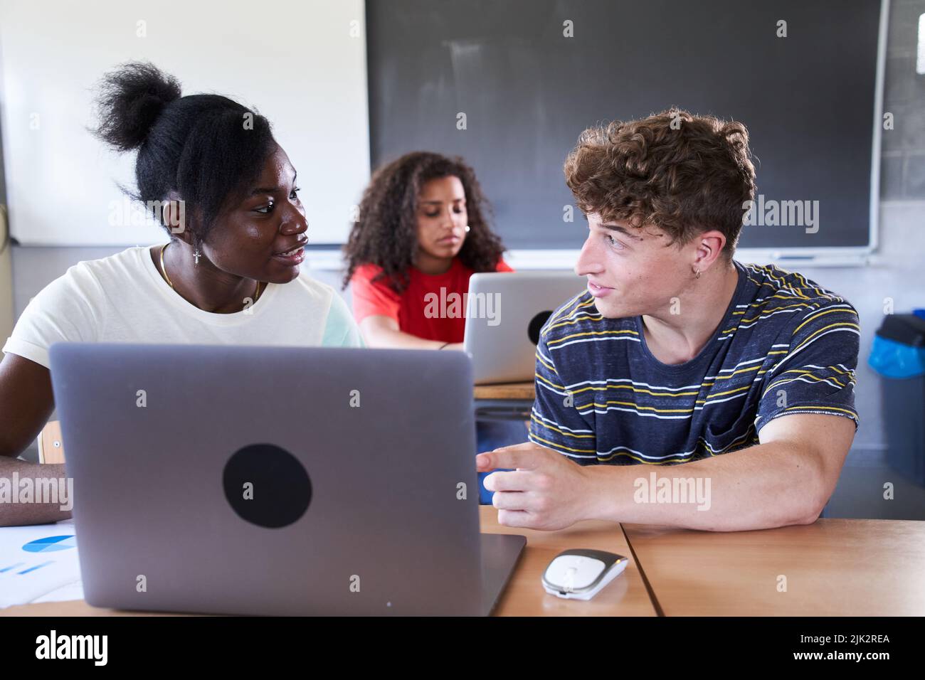 Group of students using computer laptop preparing for exam in ...