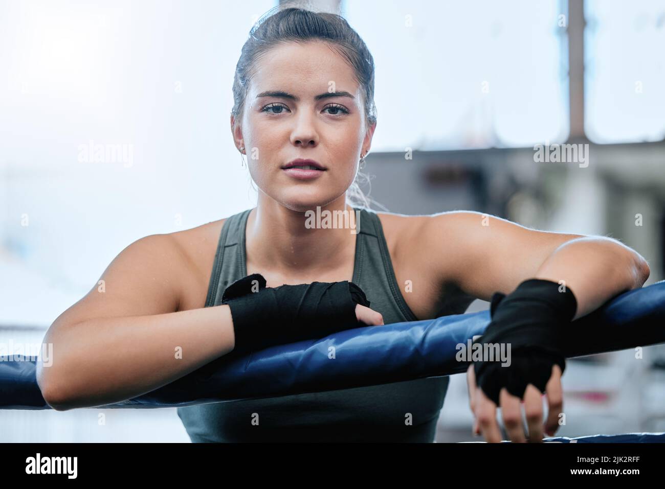 Confident, active and toned female fitness athlete in a boxing ring ...