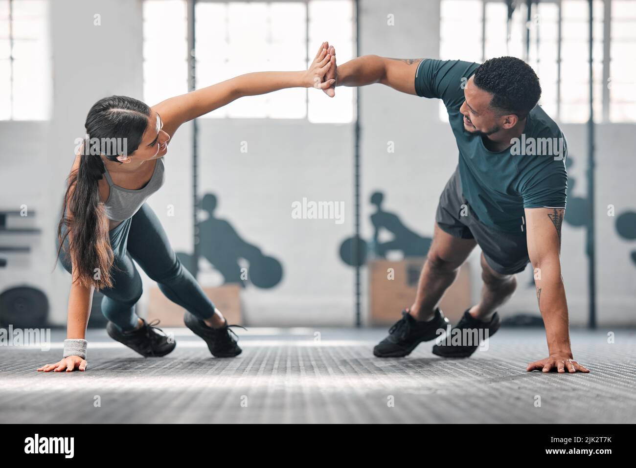 Healthy, fit and active gym partners exercising together as a couple ...