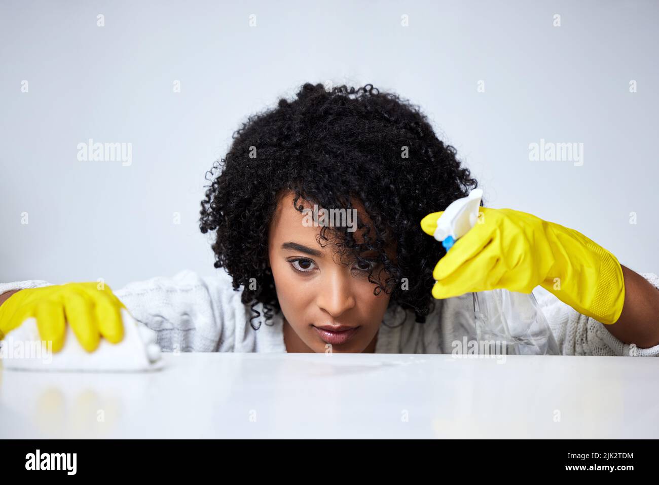 This counter will shine when im done. a young woman spraying down a ...