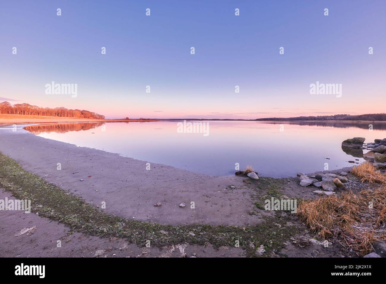 Beautiful, fresh and colorful nature at sunset with calm water near ...