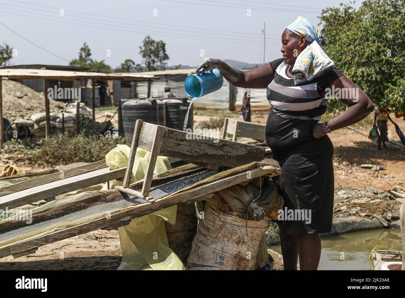 A woman is seen mixing crushed ore with water to make a concentrate at ...
