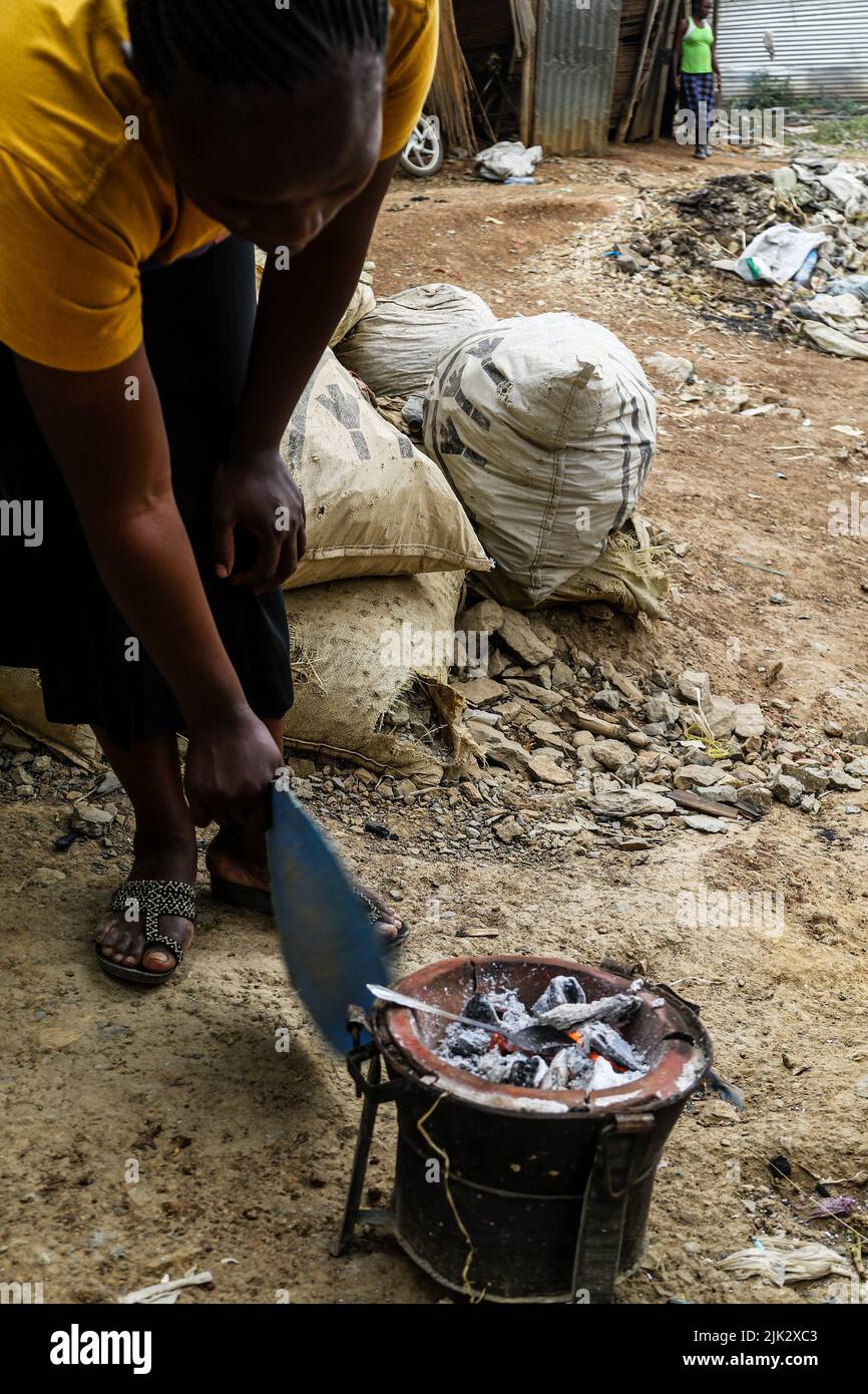 An artisanal miner is seen heating a piece of gold in a charcoal fired ...