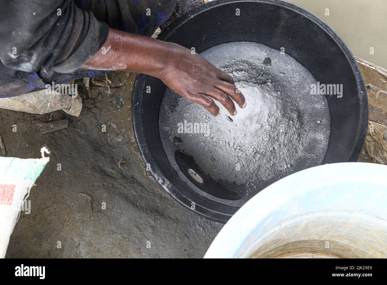 An artisanal miner is seen mixing crushed ore with mercury and water at ...
