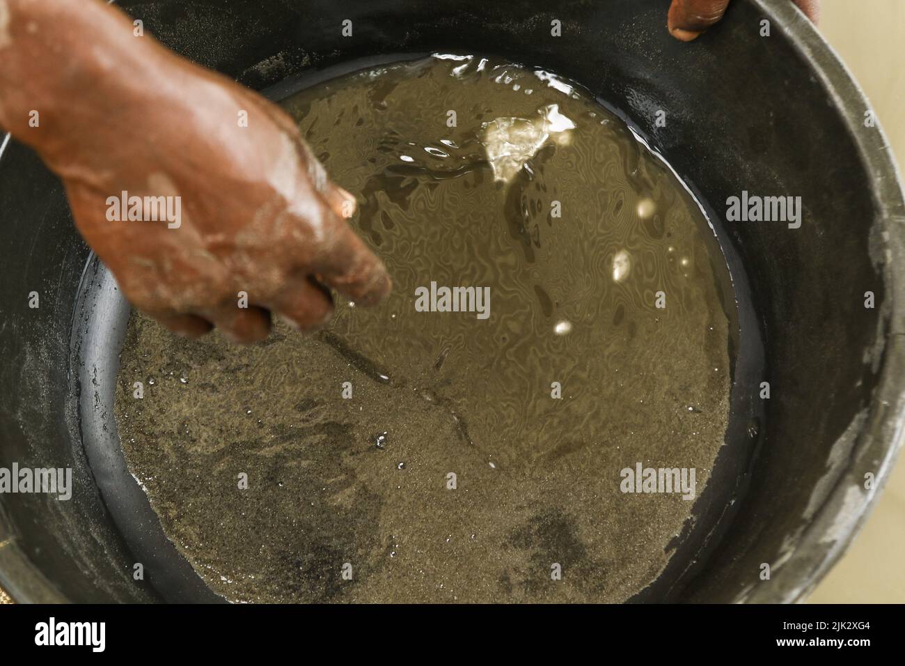 An artisanal miner is seen mixing mud containing gold with mercury at a ...