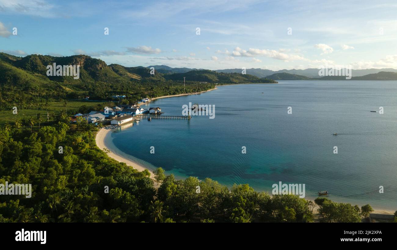 drone view of tropical island, hills and forest by the beach in the ...