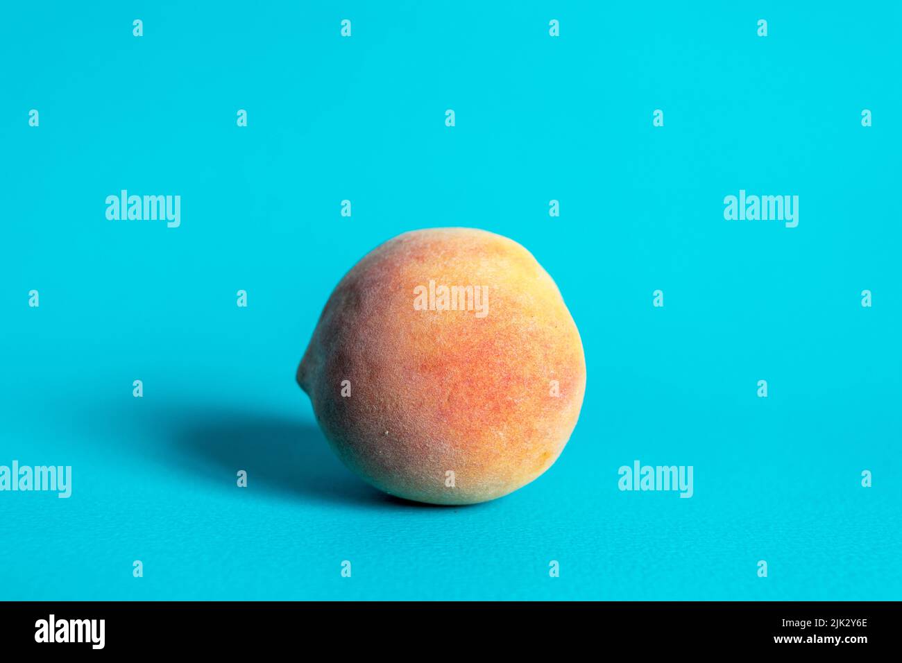 Peach on a blue background Stock Photo - Alamy