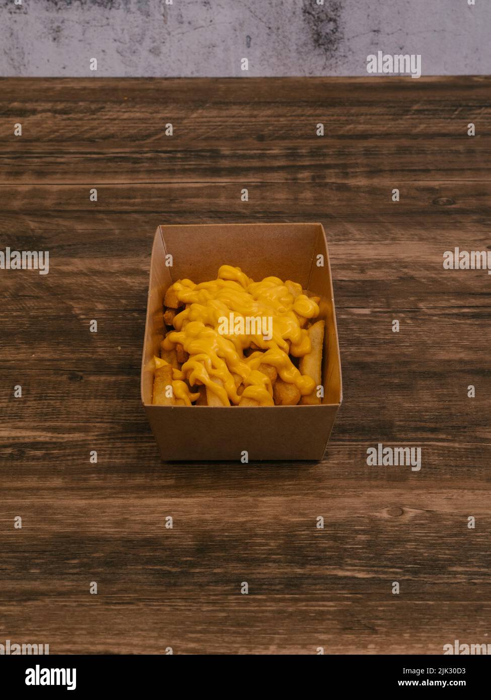 Cheese Fries in a cardboard tray with nacho cheese Stock Photo - Alamy