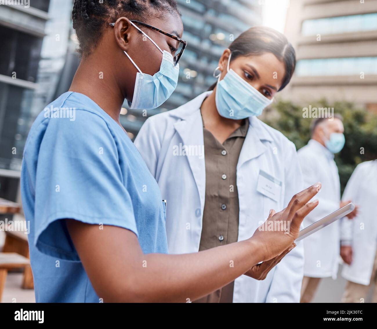 Its as easy as a tap of your finger. two young female doctors using a ...
