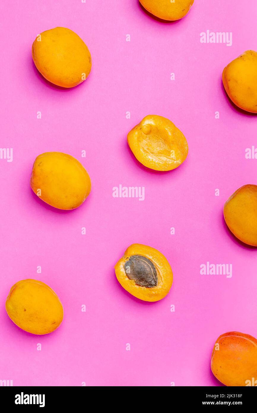 Apricot pattern. Top view of fresh fruit on a pink background ...