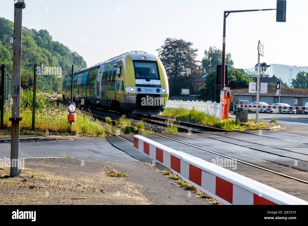 Train circulating on crossing with a road, the safety barrier is down ...