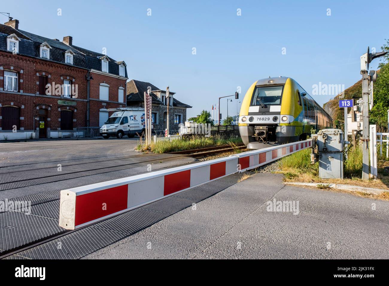 Train circulating on crossing with a road, the safety barrier is down ...