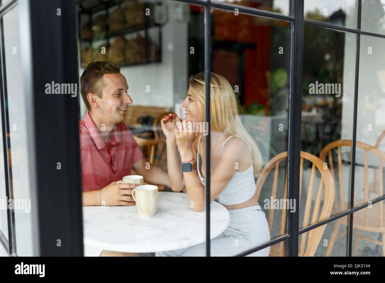 Romantic loving couple drinking coffee, having a date in the cafe, view ...