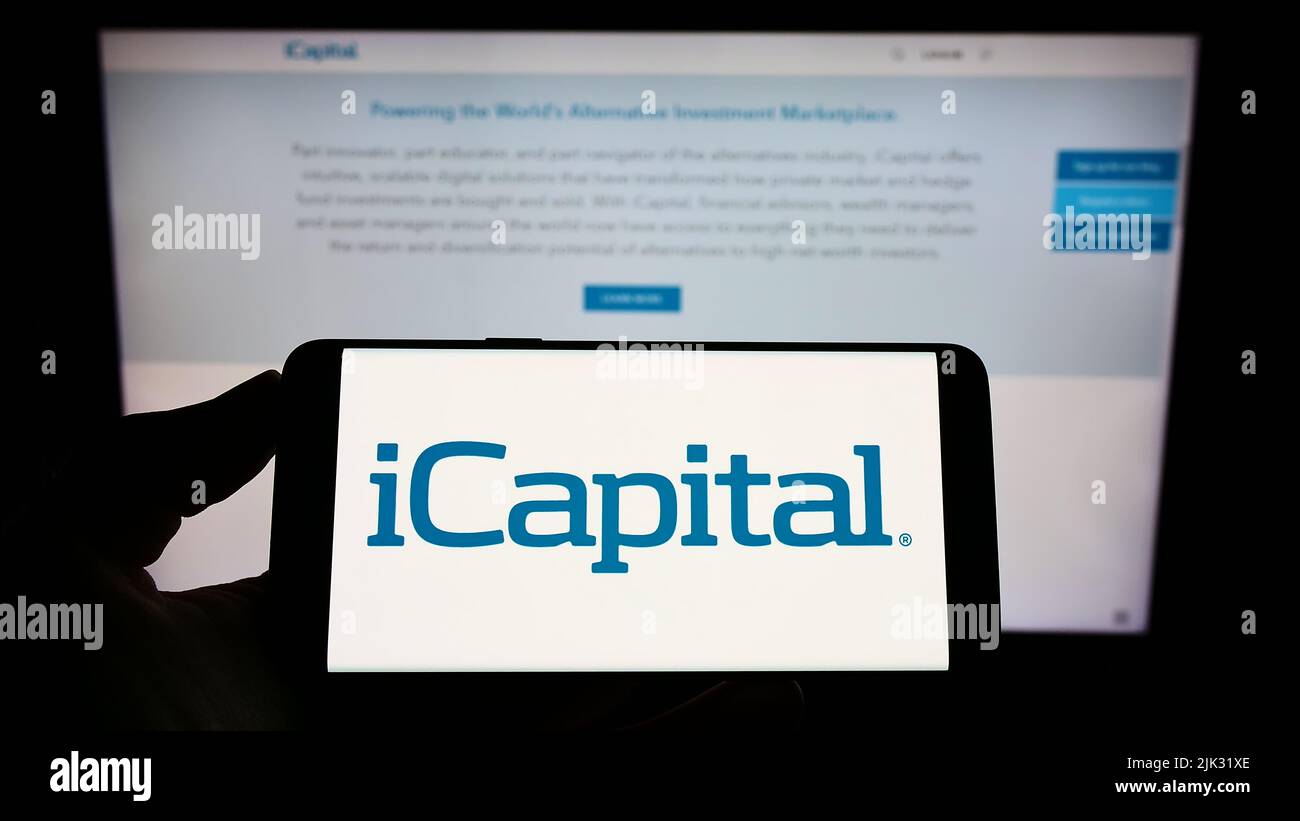 Person holding mobile phone with logo of Institutional Capital Network ...