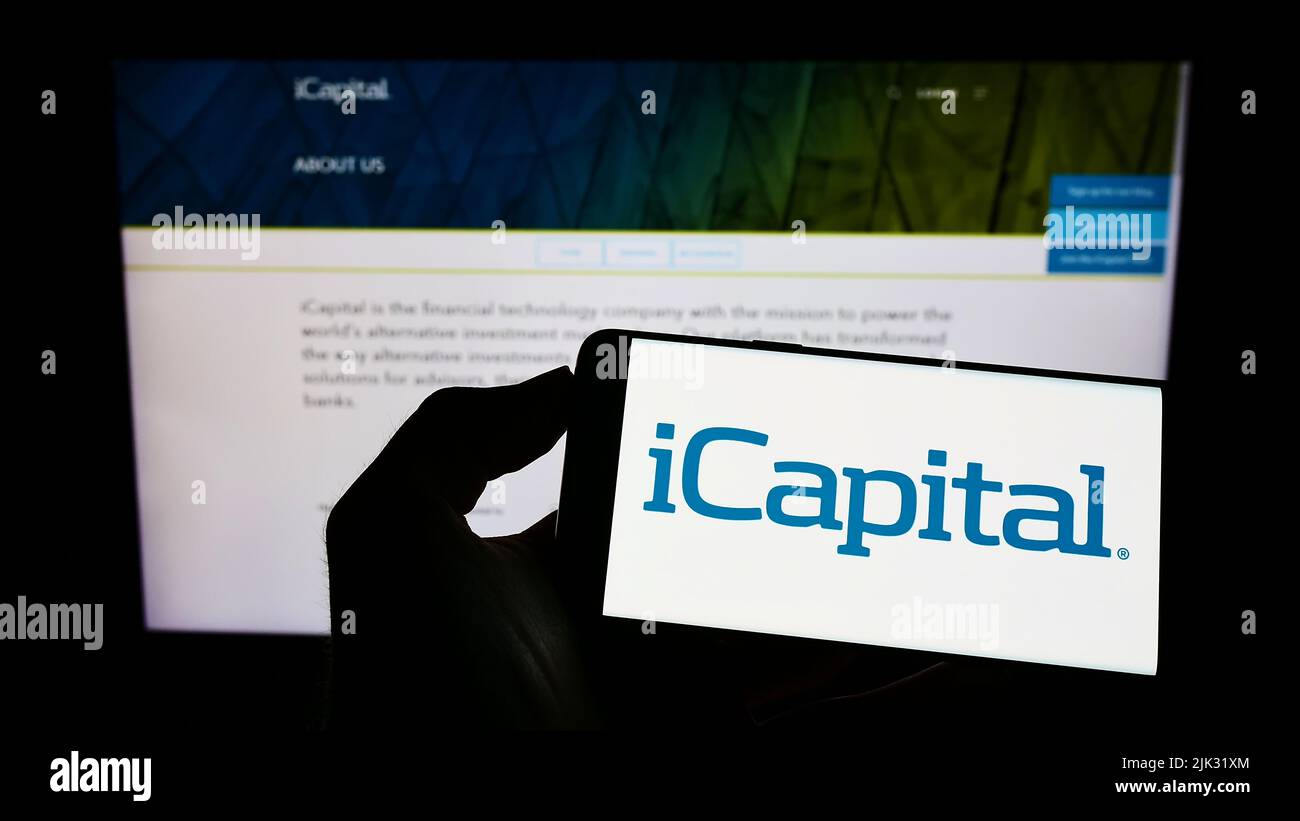 Person holding cellphone with logo of Institutional Capital Network Inc ...