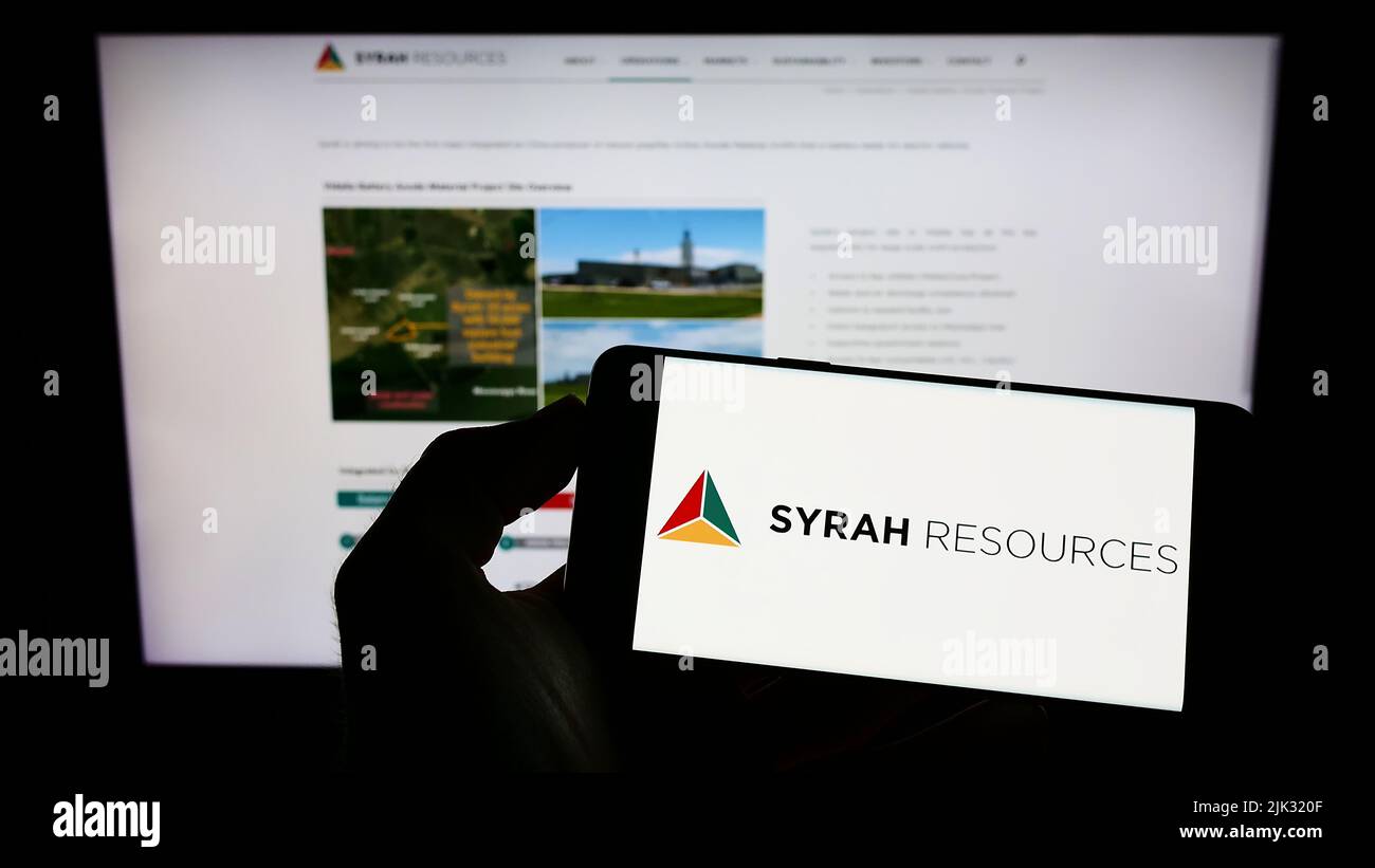 Person holding cellphone with logo of Australian company Syrah ...