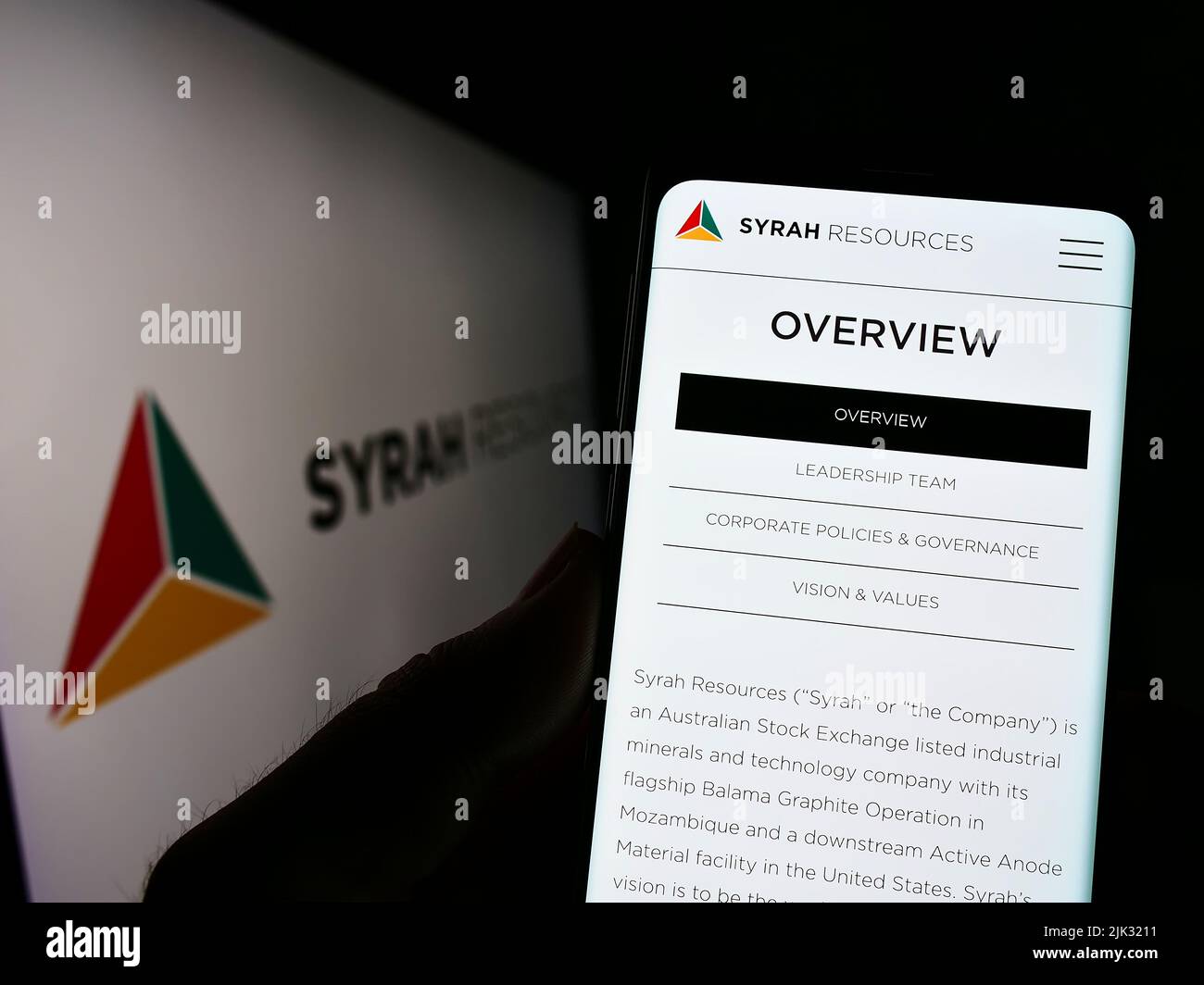 Person holding cellphone with website of Australian company Syrah ...