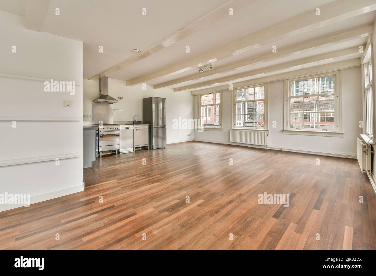 Interior of empty white kitchen with windows and wooden parquet floor ...