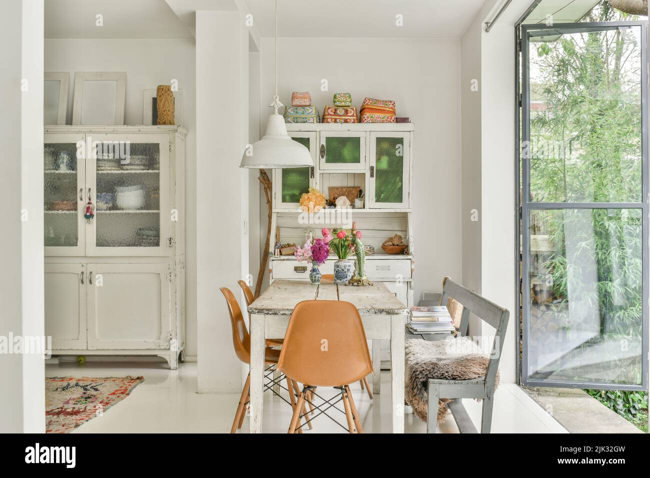 Table with chairs located under stylish plant near potted plants and ...