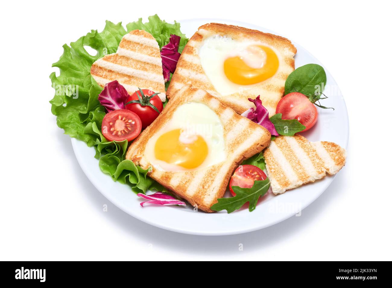 Fried egg Toasts with heart shaped holes on white ceramic plate Stock ...