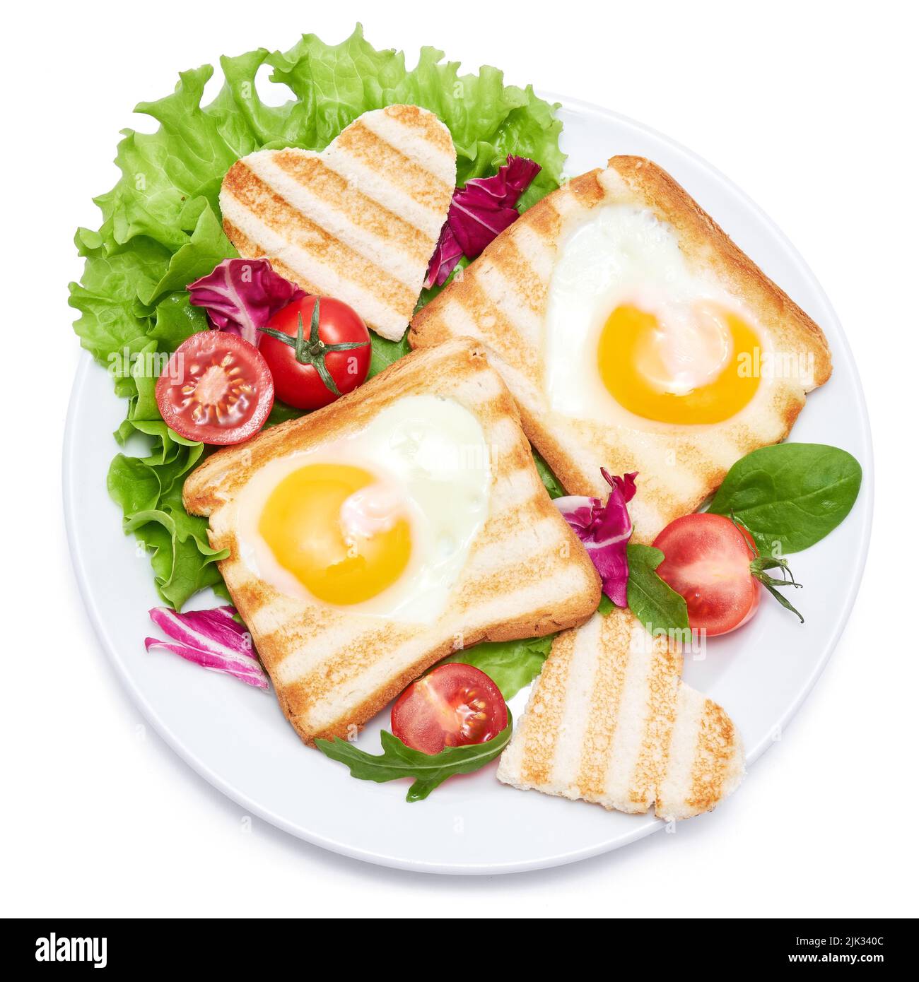 Fried egg Toasts with heart shaped holes on white ceramic plate Stock ...
