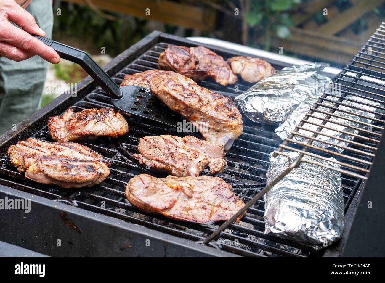 Pieces of fresh raw meat laid out on grill grate Stock Photo - Alamy
