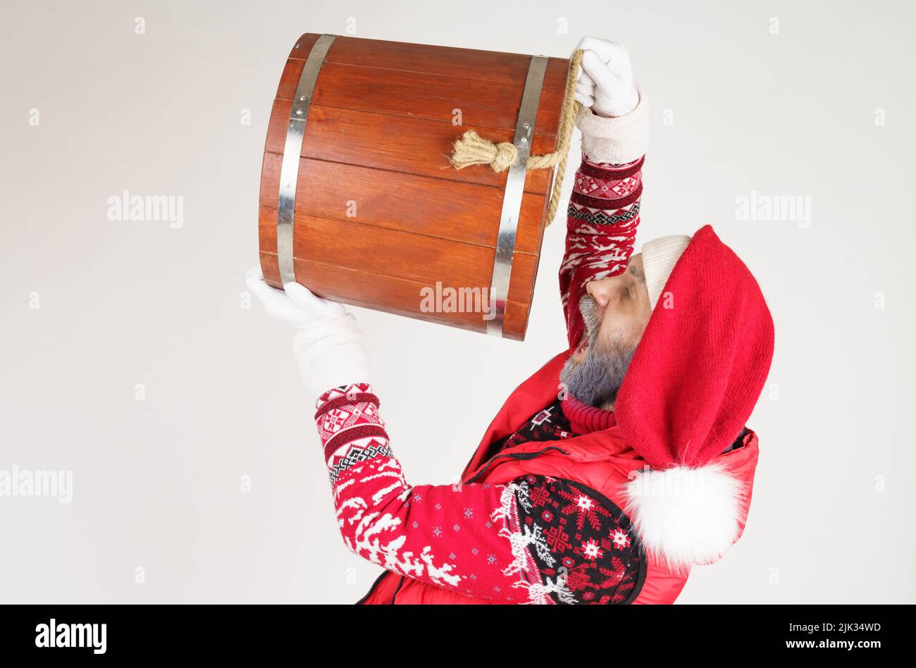 New Year and Christmas concept. Santa Claus drinks from a large wooden ...