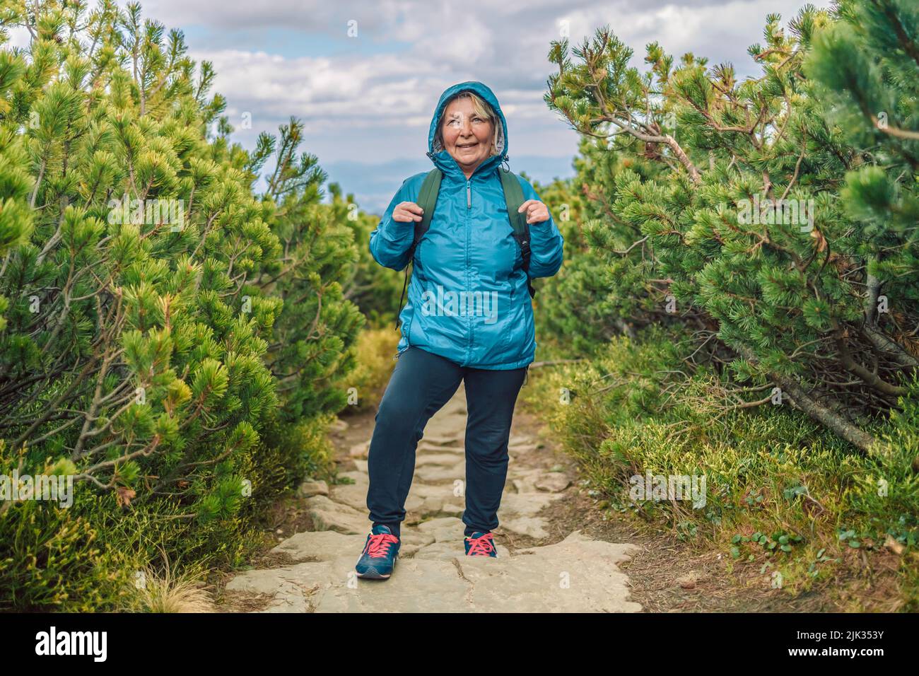 Happy 50s woman Traveler going mountains landscape on background ...