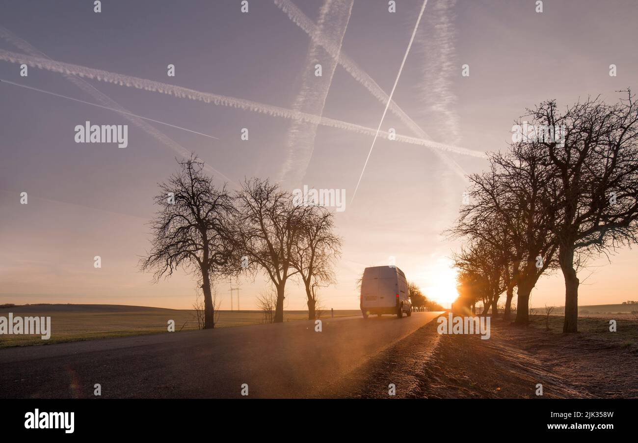 Sunrise on the road with car going forward sun Stock Photo - Alamy