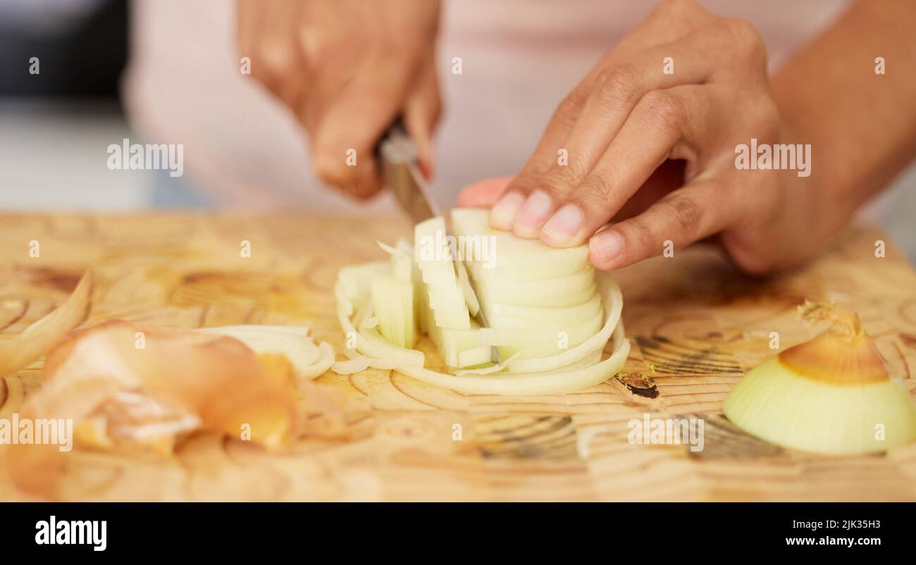 Every meal begins with a base of onions. a woman cutting an onion Stock ...