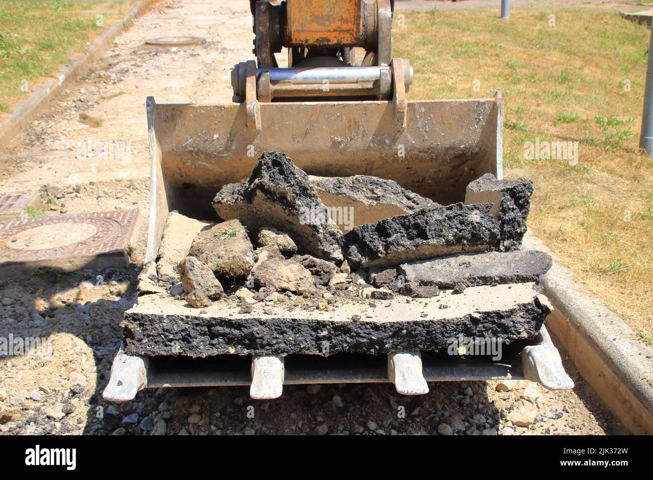 Shovel from an excavator is filled with asphalt chunks Stock Photo - Alamy