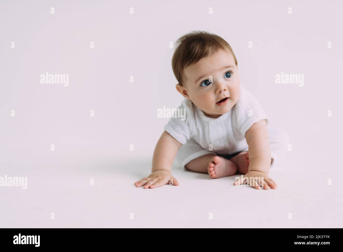 Side view of infant baby toddler in diaper and white bodysuit is ...
