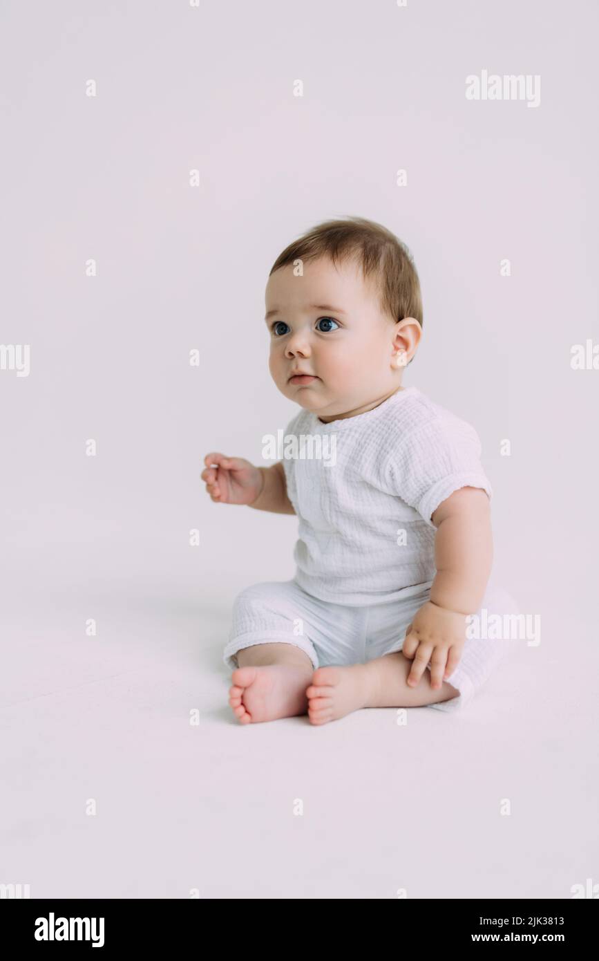 Side view of infant baby toddler in diaper and white bodysuit is ...
