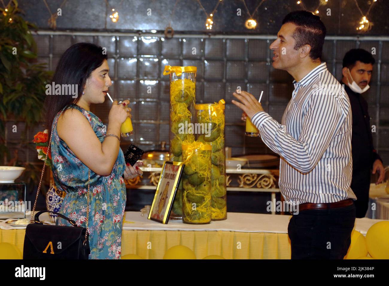 Islamabad, Pakistan. 29th July, 2022. People enjoy mango drinks during ...