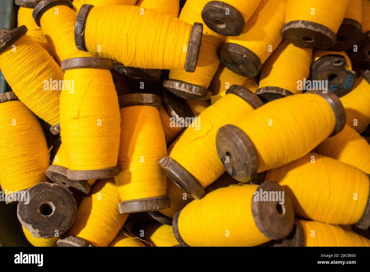 large grup yellow yarn on wood spool, yarn on tube, a collection of ...