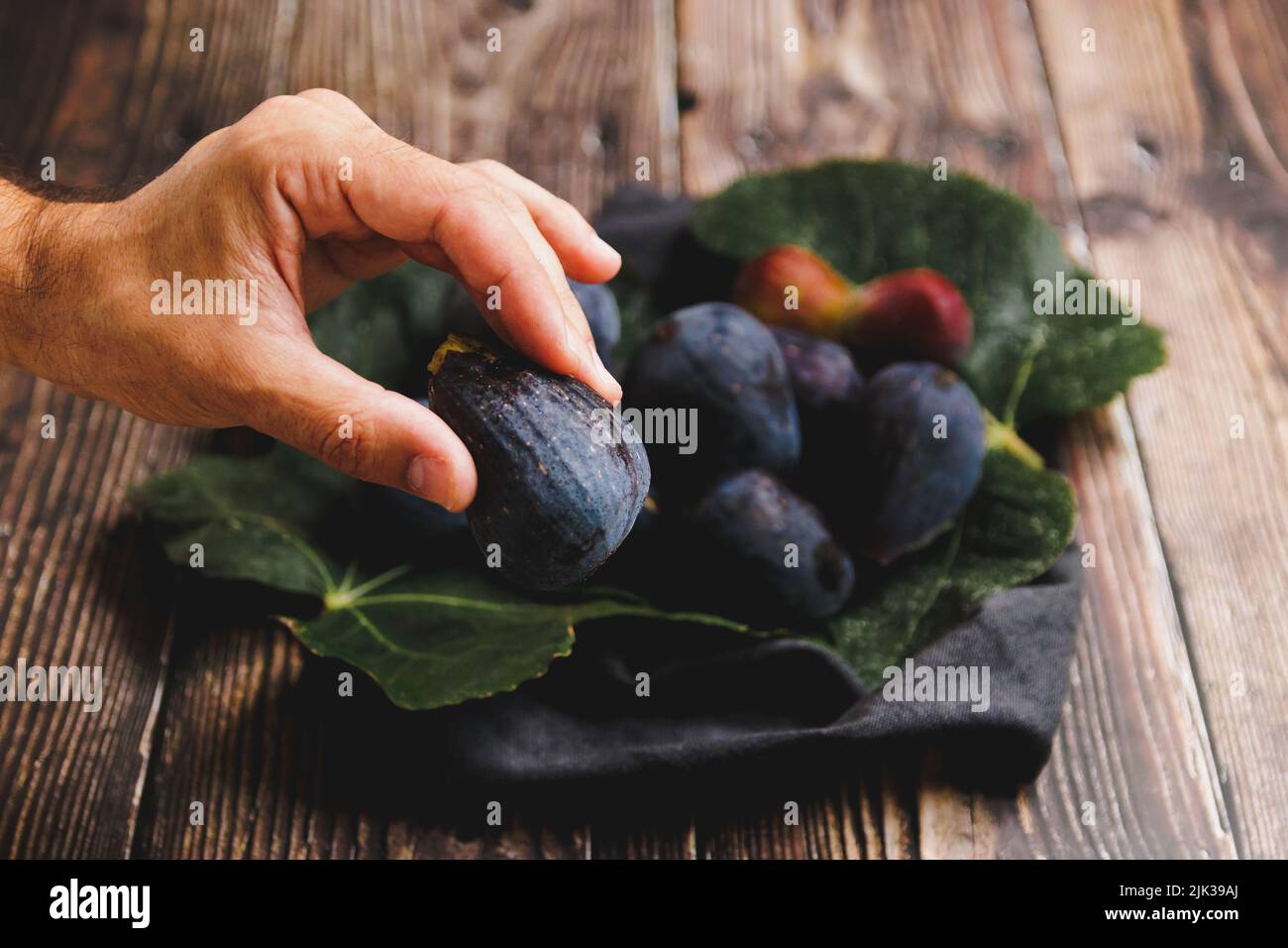Figs in fig leaves on wooden table, top view Stock Photo - Alamy