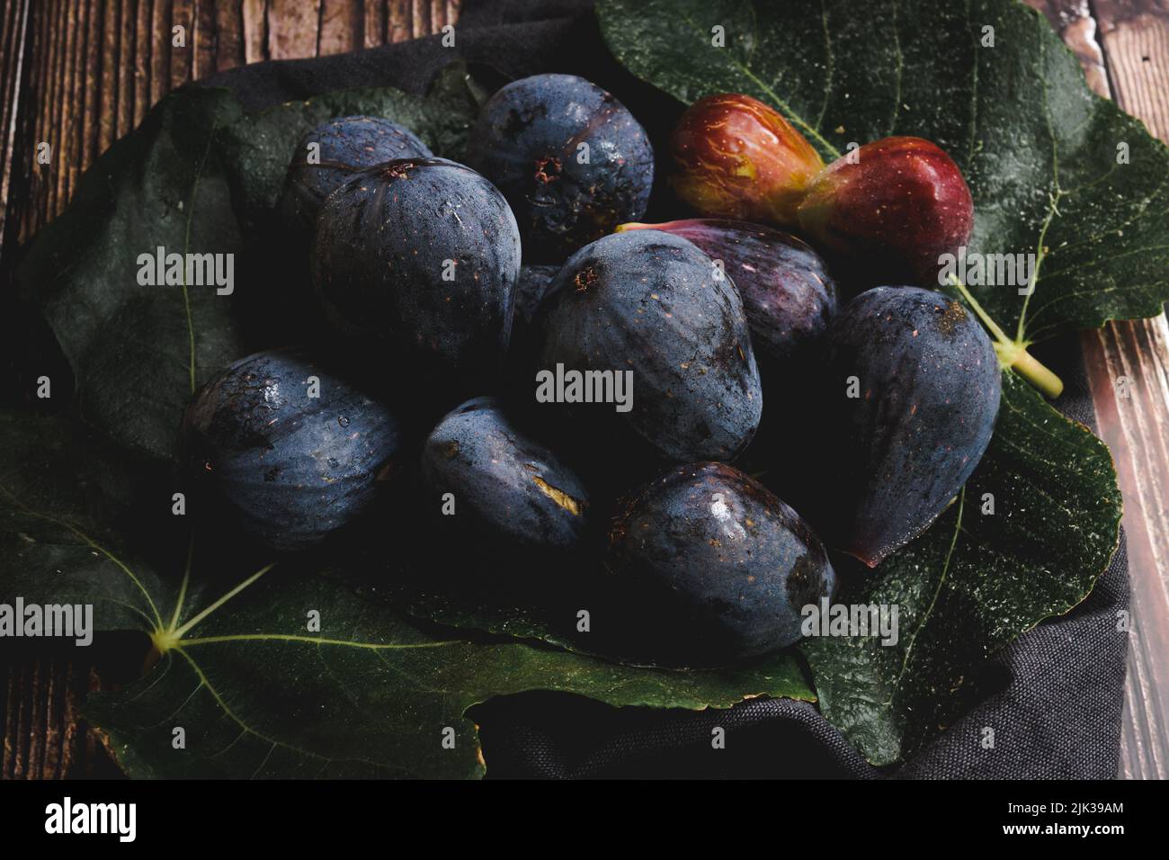 Figs in fig leaves on wooden table, top view Stock Photo - Alamy