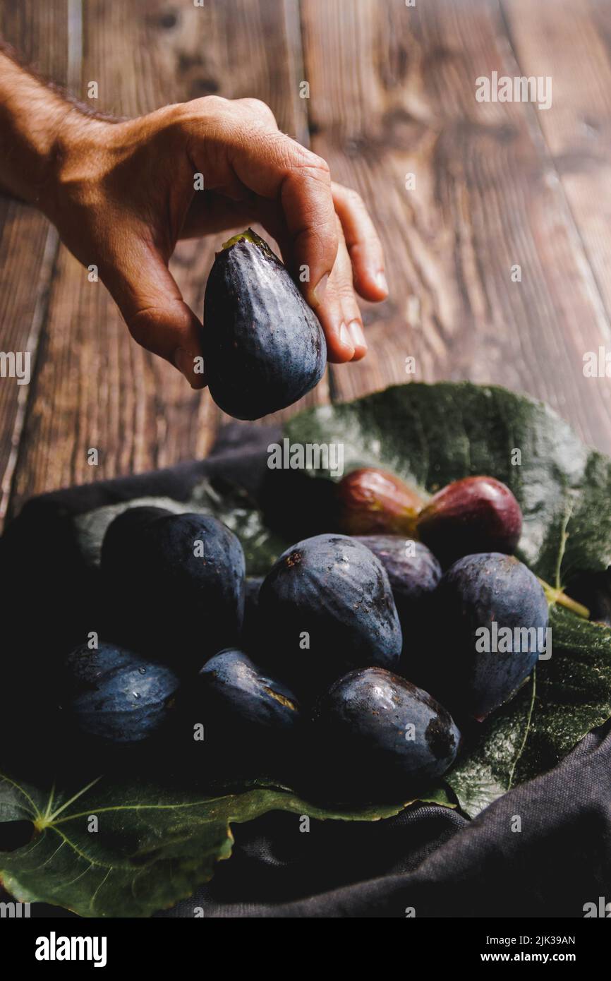 Figs in fig leaves on wooden table, top view Stock Photo - Alamy