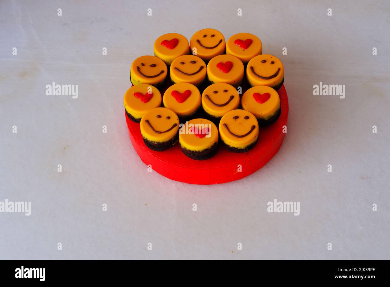 Small yellow cakes with hearth shape and smiley Stock Photo - Alamy