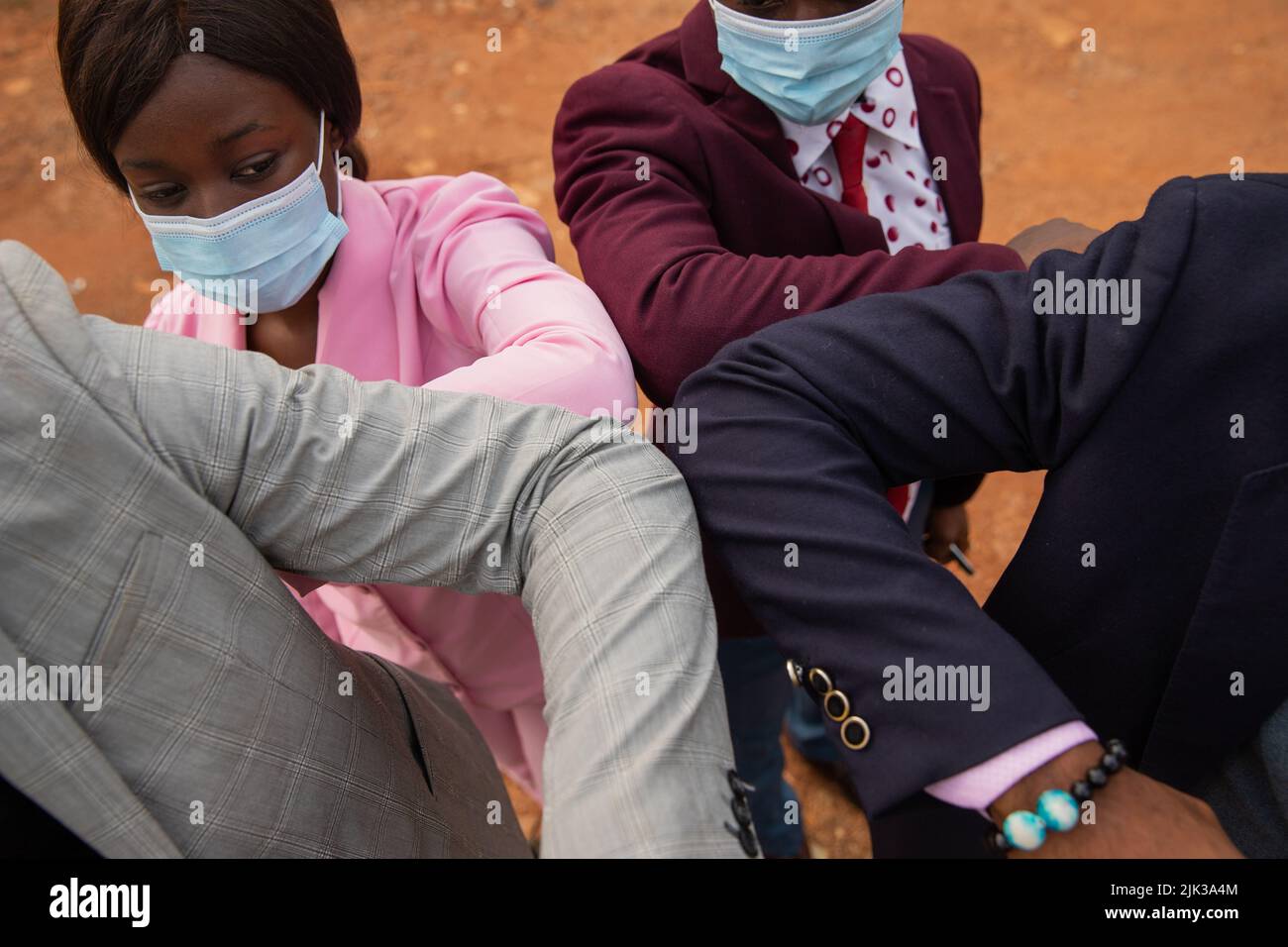 Four young adult boys and girl are playing joining their nudges. Elbow ...